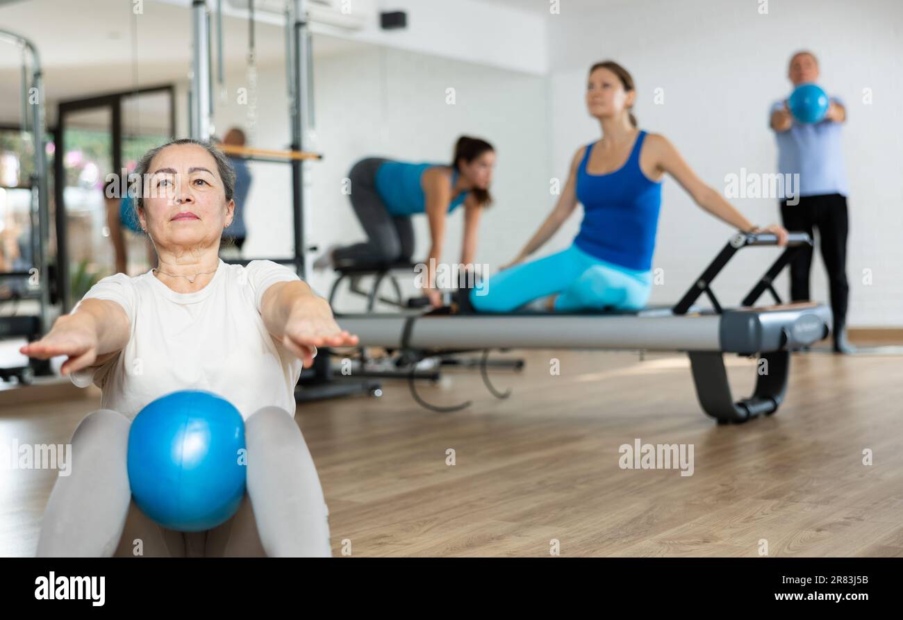 Elderly woman doing sit-ups with pilates bender ball Stock Photo - Alamy