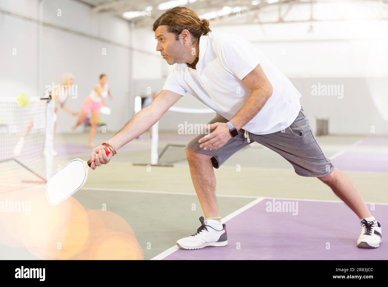 Adult man playing friendly pickleball match on closed court Stock Photo ...