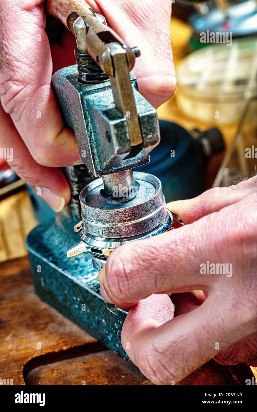 Wrist and pocket watches, gears, springs on an artisan's table: a ...