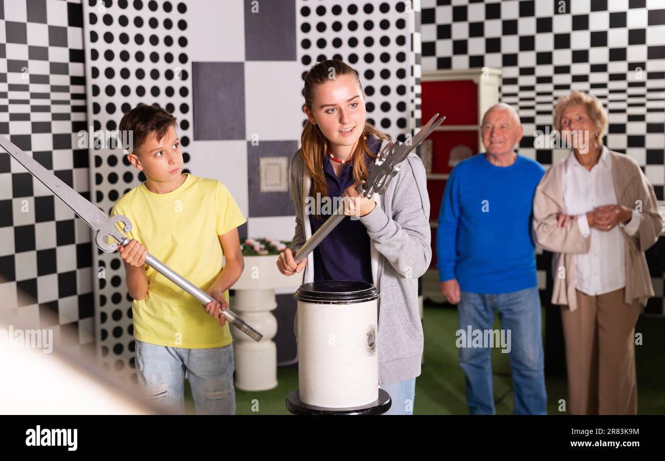 Kids solving conundrum in escape room and grandparents watching them ...
