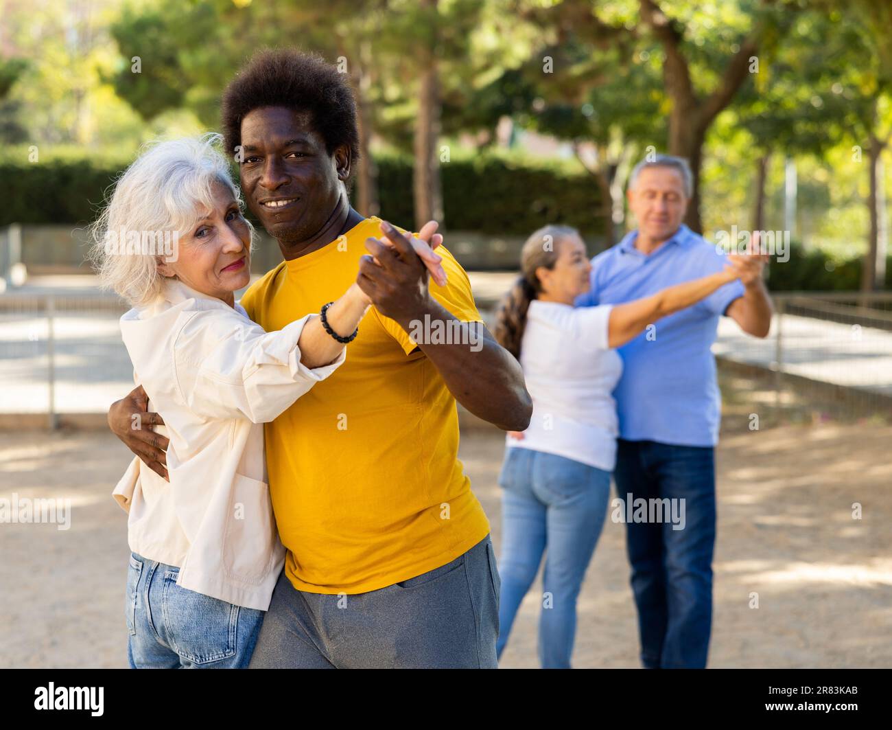 Happy positive smiling adult friends dancing pair dance in garden Stock ...