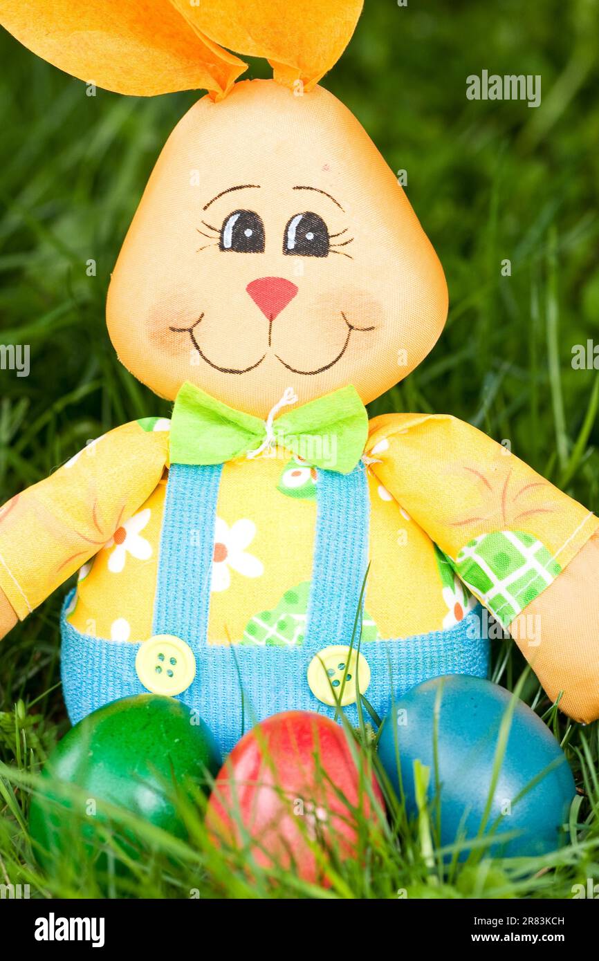 Toy easter bunny in the garden with coloured easter eggs Stock Photo ...