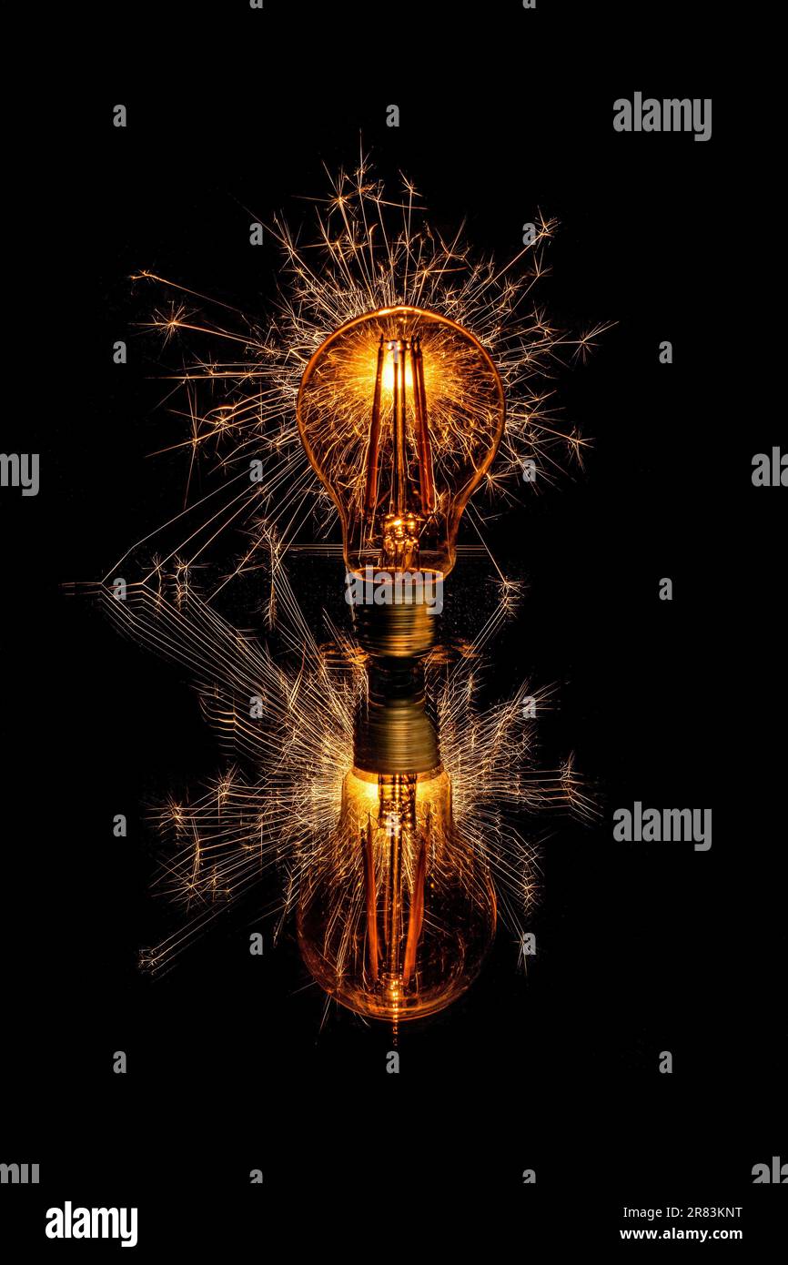 Burning sparkler behind a lightbulb Stock Photo - Alamy