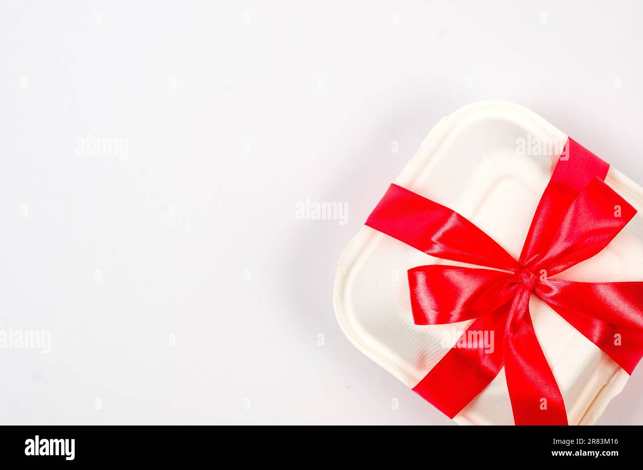 Closed bento cake box with tied red ribbon. Gift box with tasty bento ...