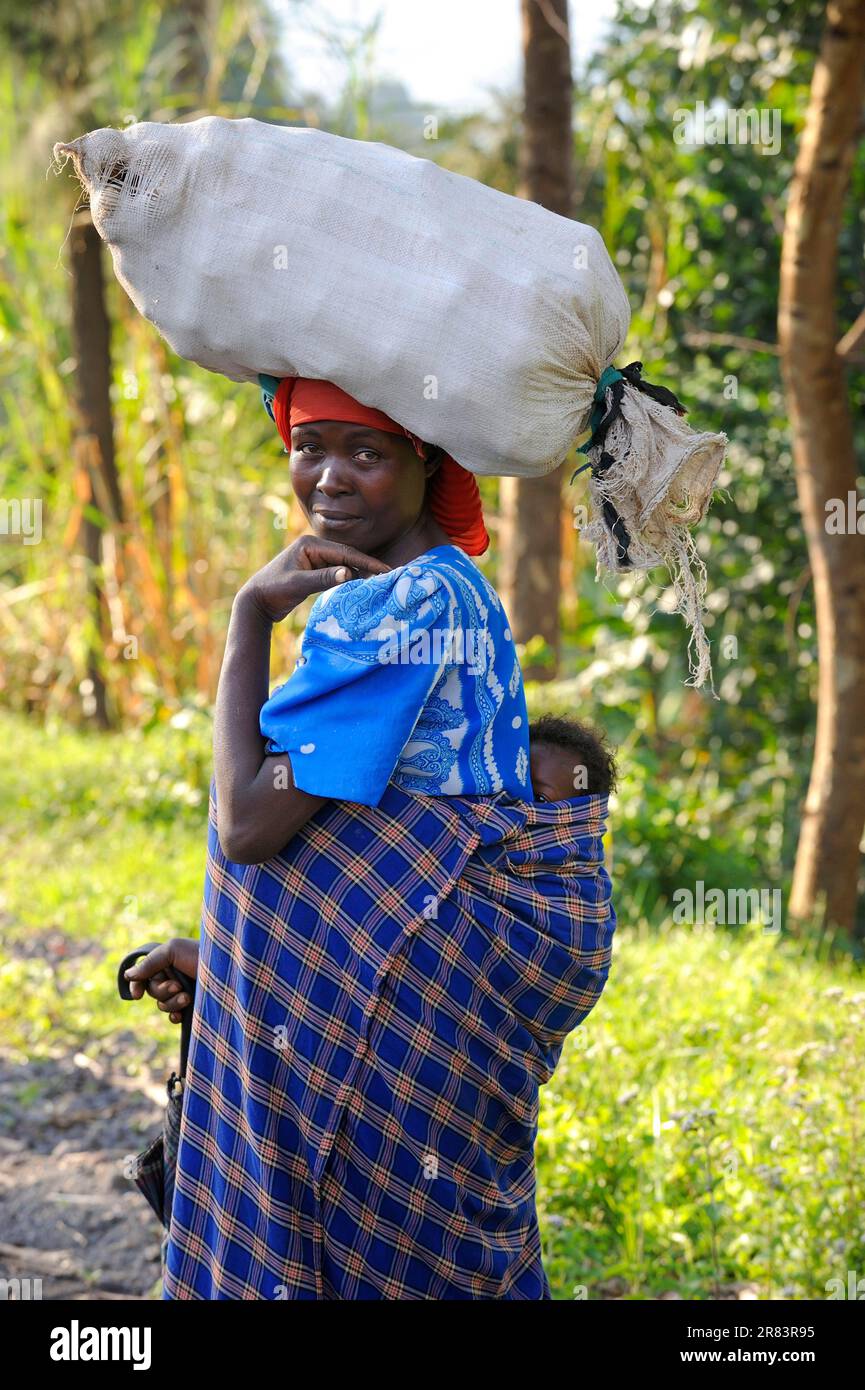 Woman with baby, carrying sack with taro on head, Rwanda Stock Photo ...