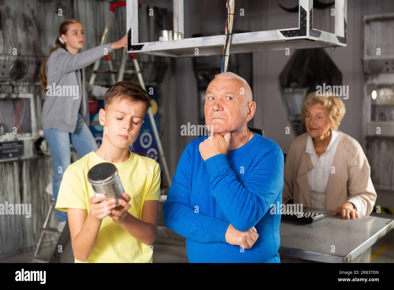 Kids and grandparents solving conundrum in quest room Stock Photo - Alamy