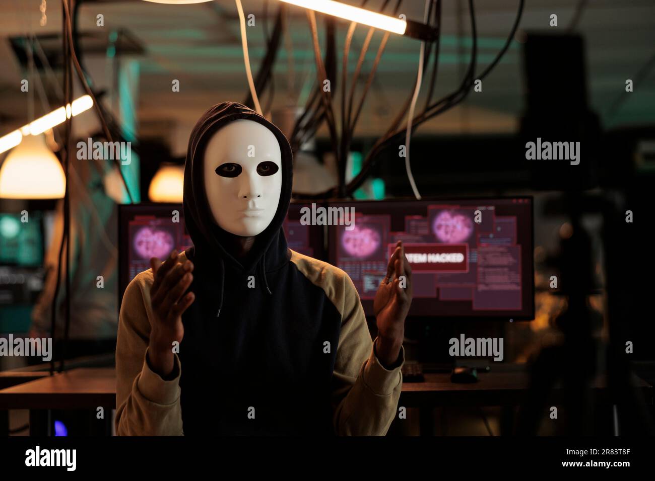 African american hacker broadcasting threat video at night, wearing ...