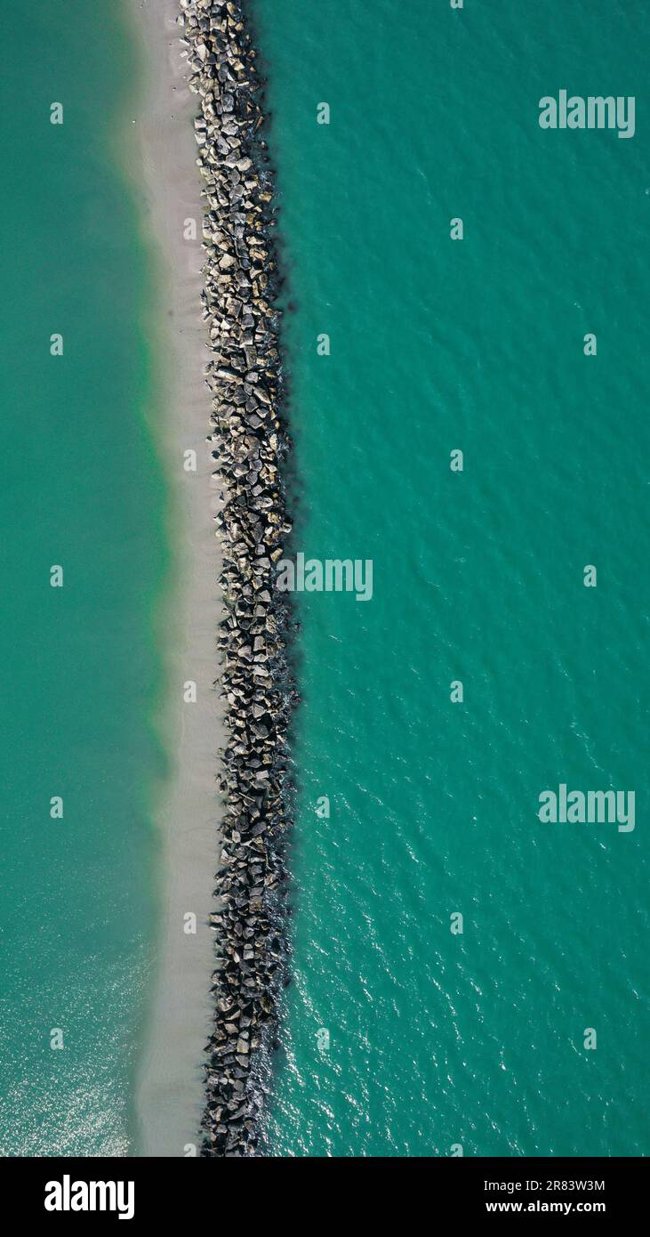 An aerial view of Waves hitting sandy rock barrier Stock Photo - Alamy