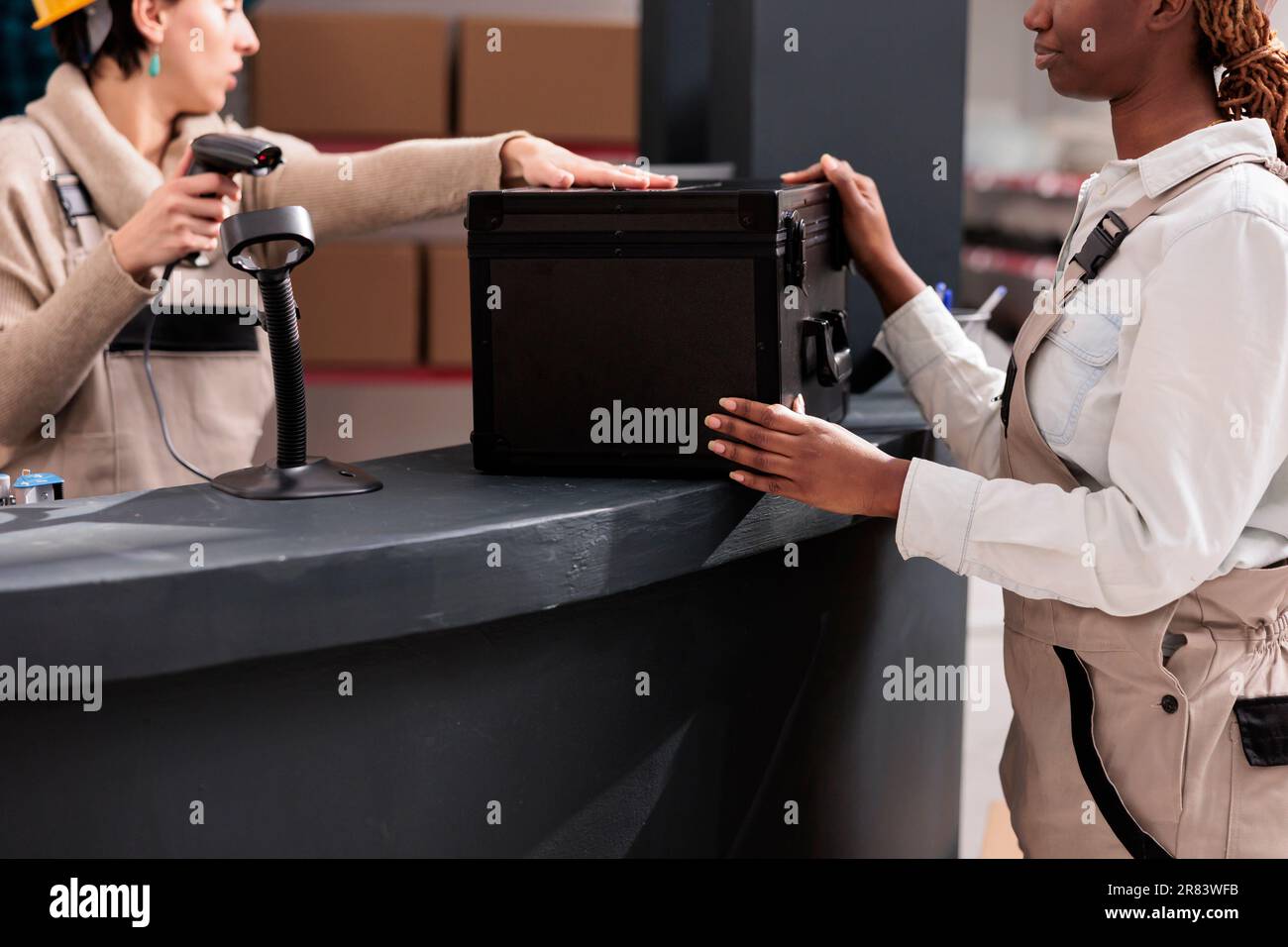 Warehouse reception worker scanning product and checking price for ...