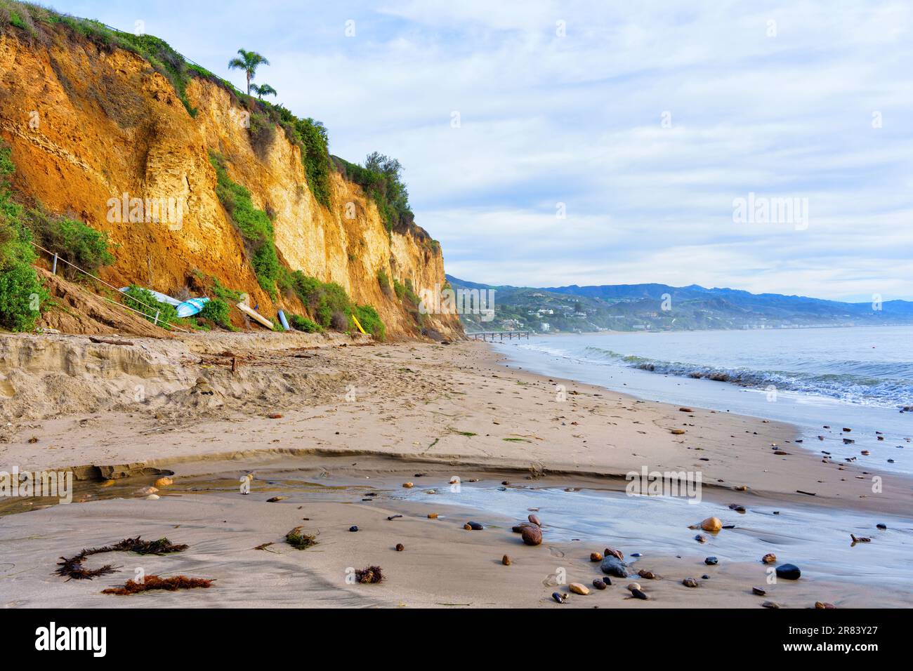 A beautiful coastal landscape with a rocky cliff, sandy shore and ocean ...
