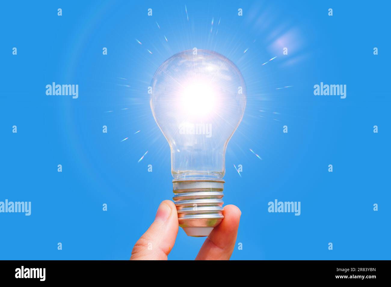 Handheld light bulb emitting a brilliant glow, casting its radiant ...