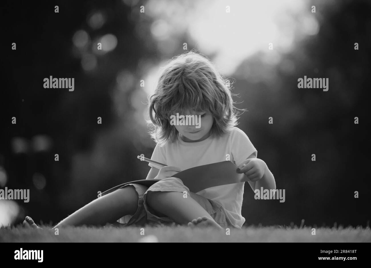 Distance kids learning. Preschool pupil in park on grass Stock Photo ...