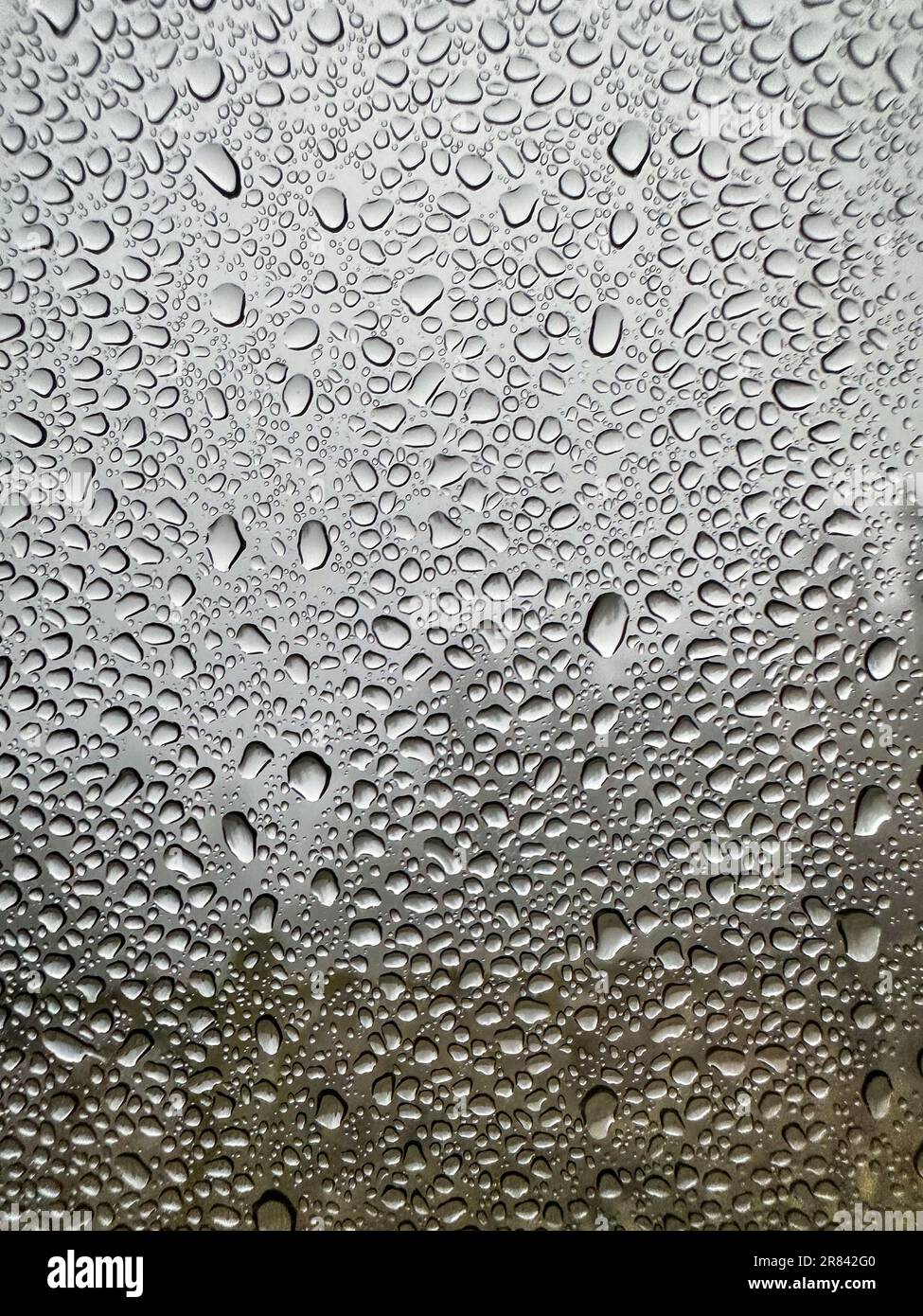 A window with condensation droplets on the inside, creating an abstract ...