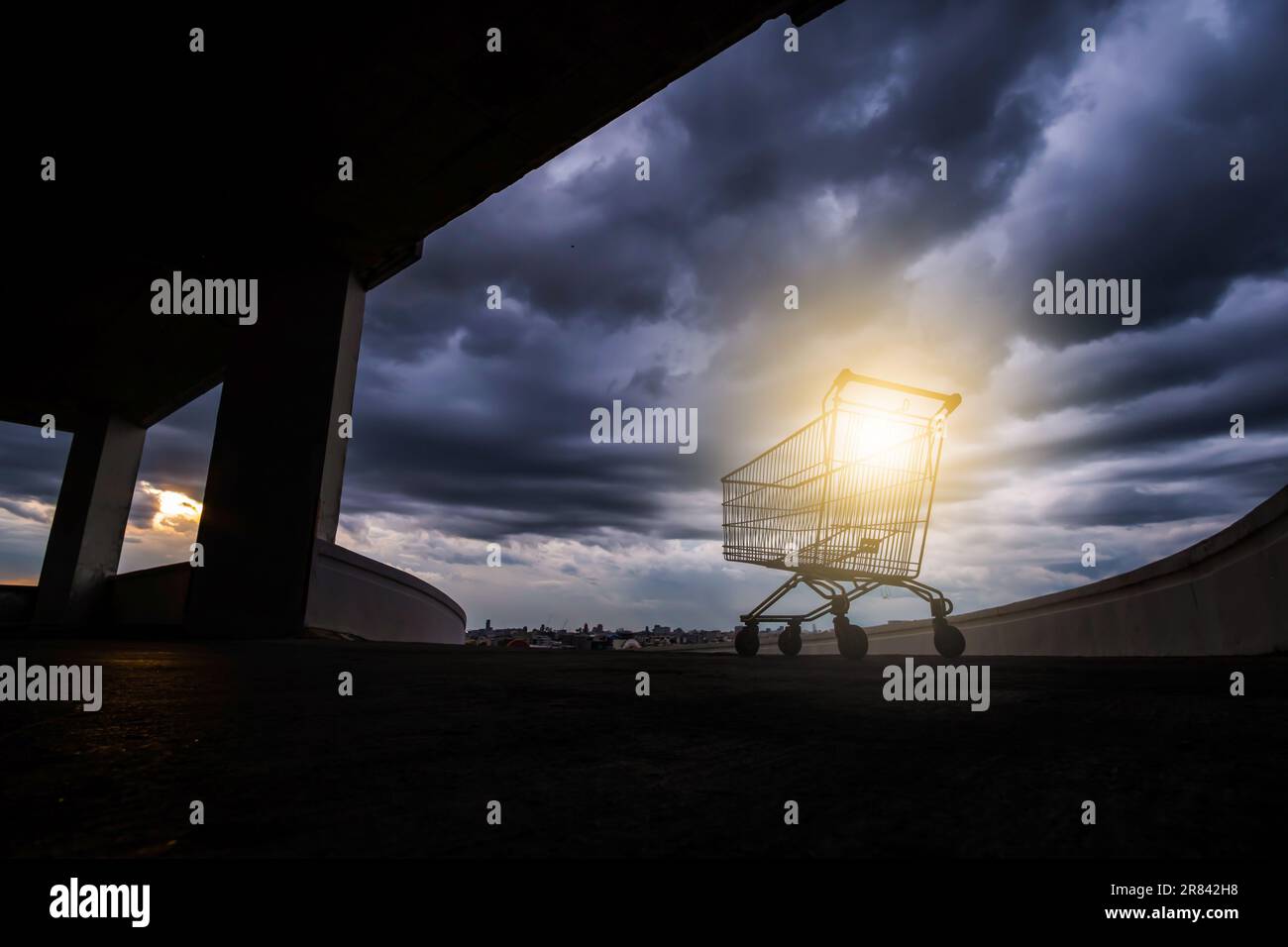 A shopping cart on a rooftop car park of an abandoned mall, the sun ...