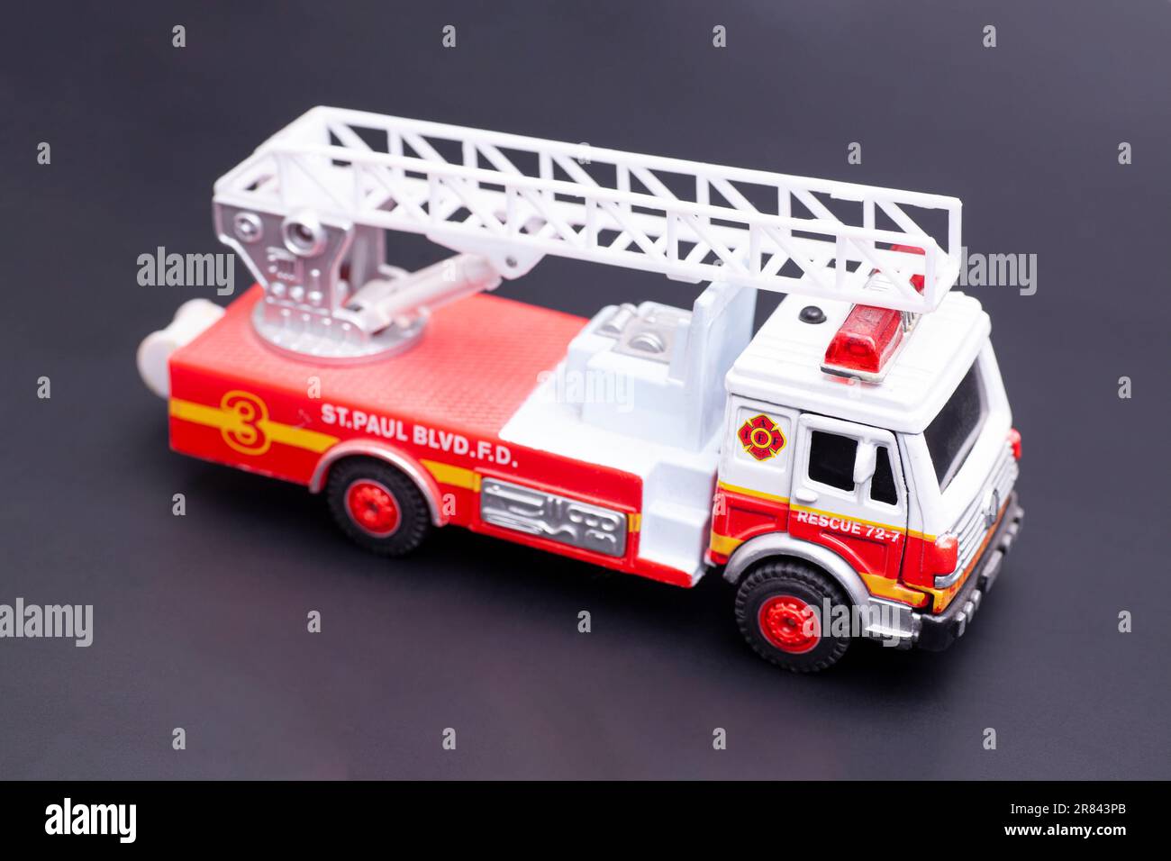 Red fire engine toy on black background Stock Photo - Alamy
