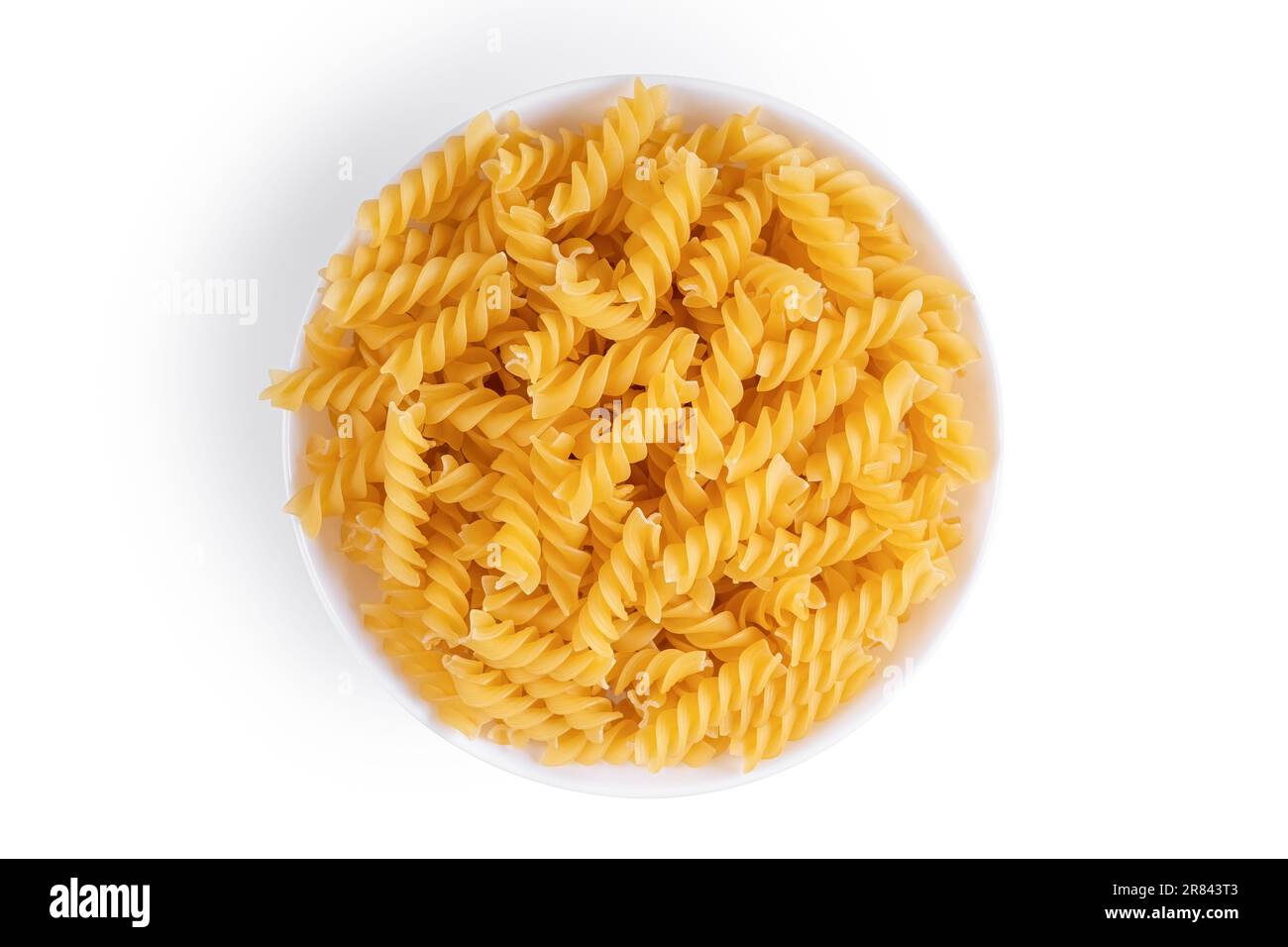 Fusilli in bowl and isolated on white background. Raw pasta spiral ...