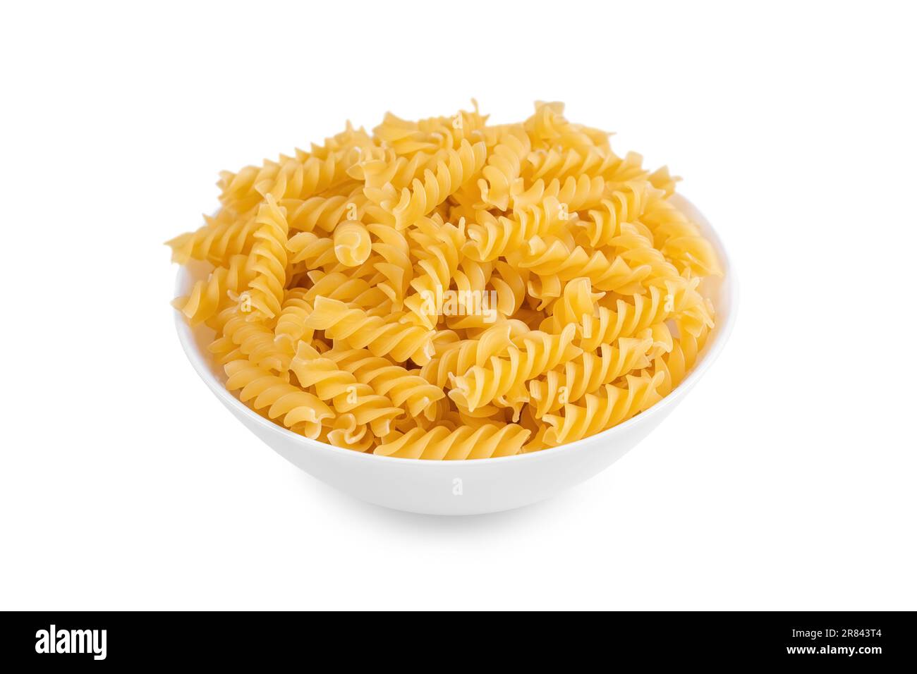 Fusilli in bowl and isolated on white background. Raw pasta spiral ...