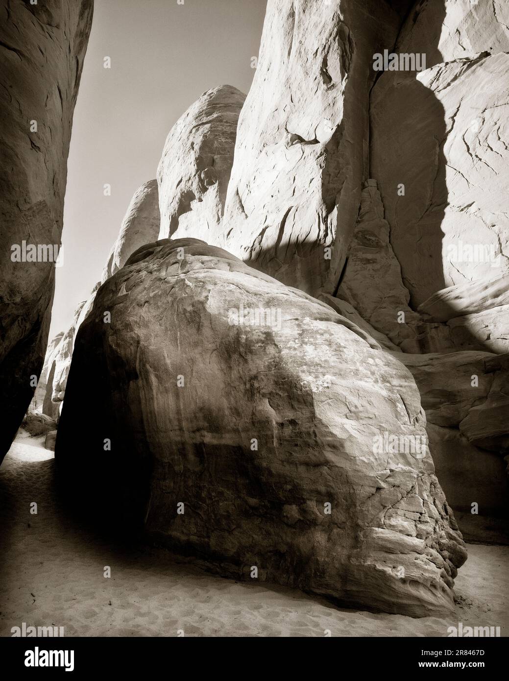 A large boulder sit in between two large valley walls in the depths of ...
