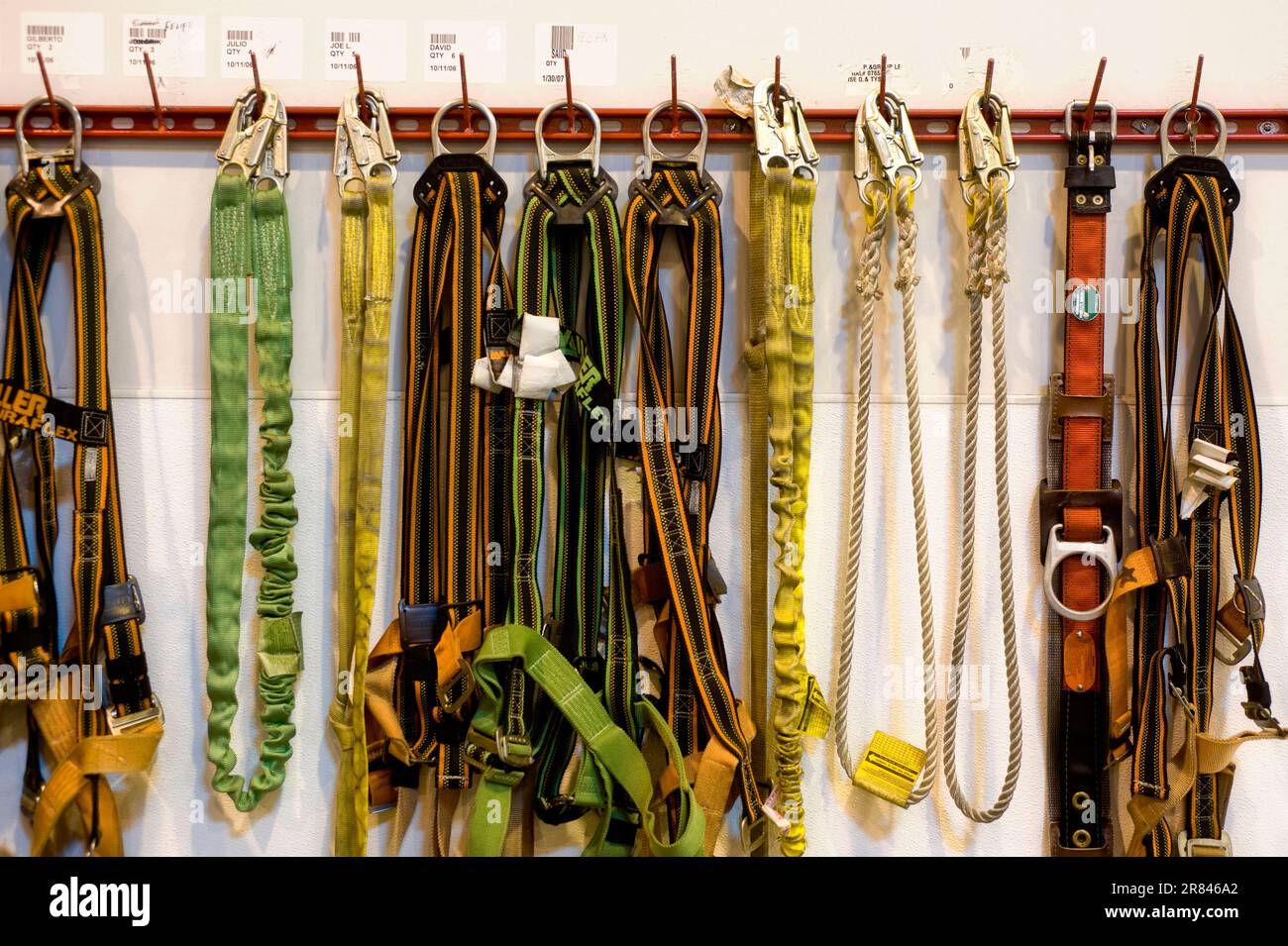 Safety harnesses of all colors line the wall in a warehouse Stock Photo ...