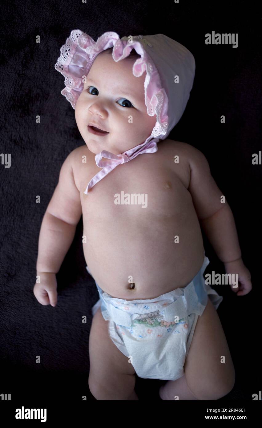 A portrait of a baby girl wearing a pink bonnet Stock Photo - Alamy
