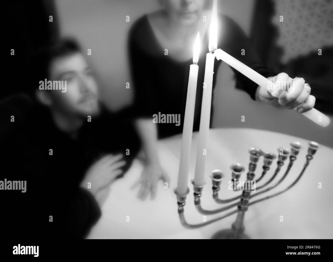 A Jewish family celebrates Hanukkah at home by lighting the candles of ...