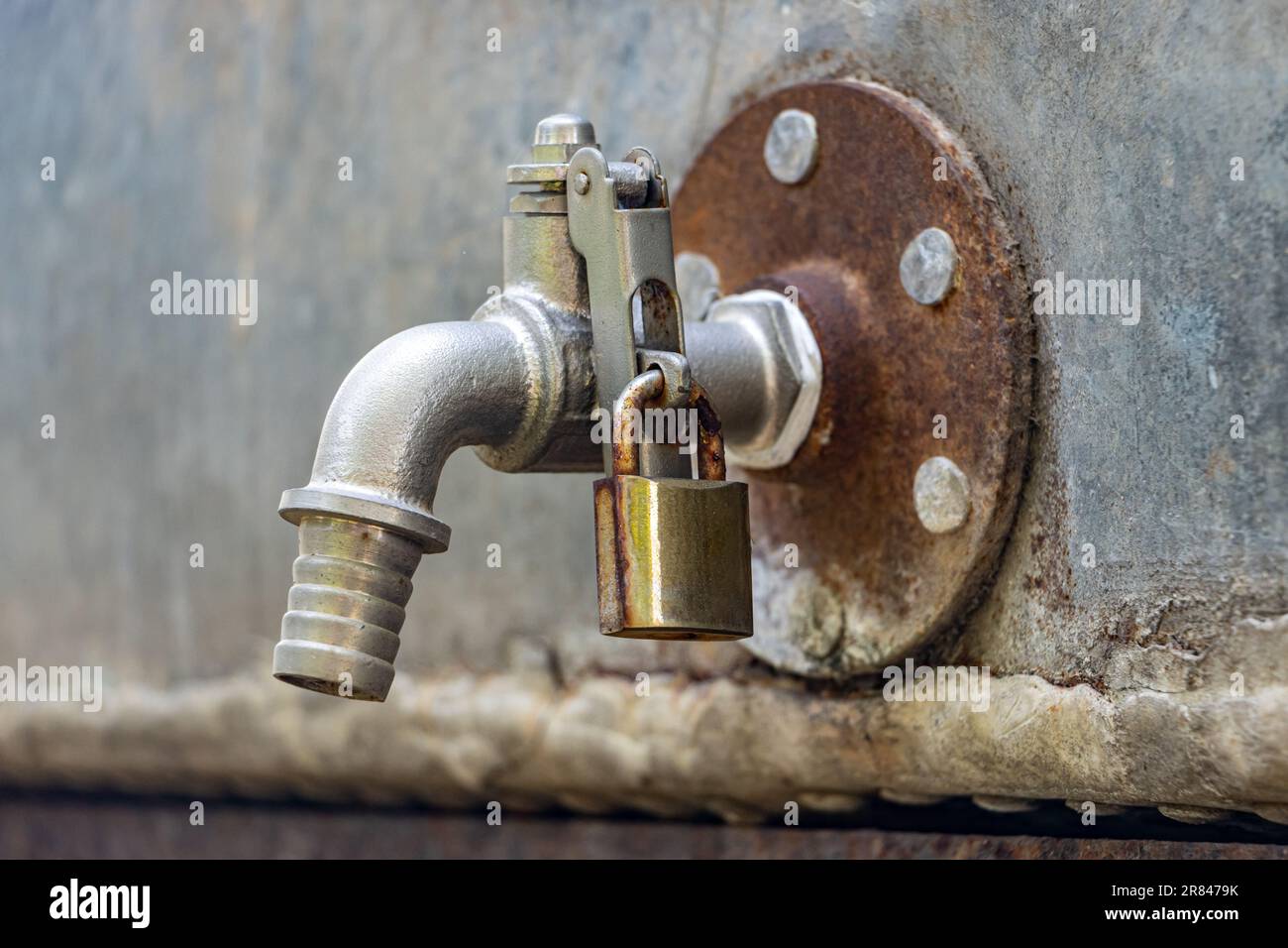 A water tap on the cistern locked with a padlock, close up Stock Photo ...