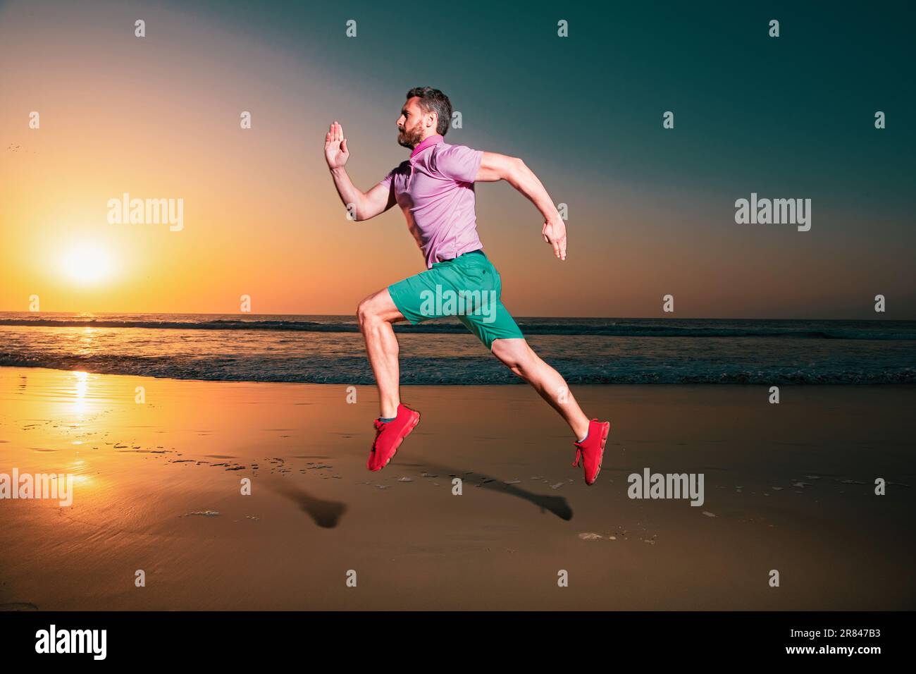 Man running on the beach at sunset. Guy runner jogger running. Dynamic ...