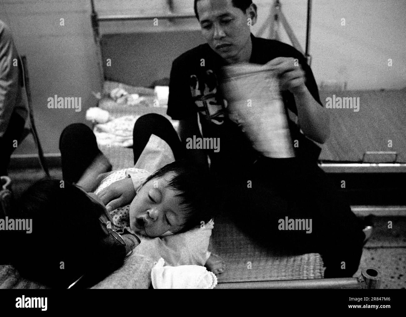 A father fans his son and wife prior to is sons operation at Hanoi ...