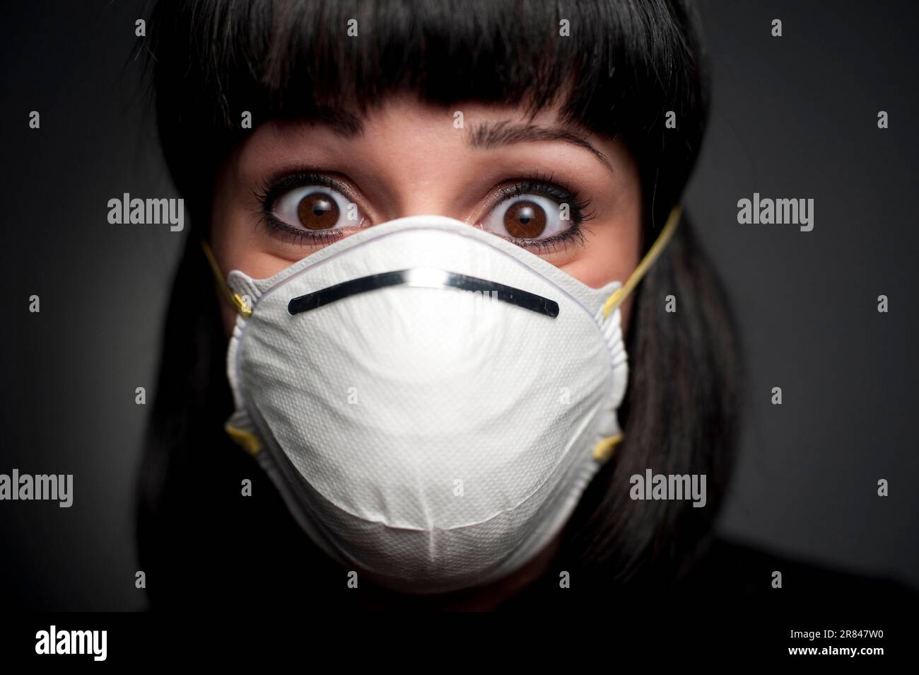 Studio portrait of 25 year old caucasian female wearing a N95 mask ...