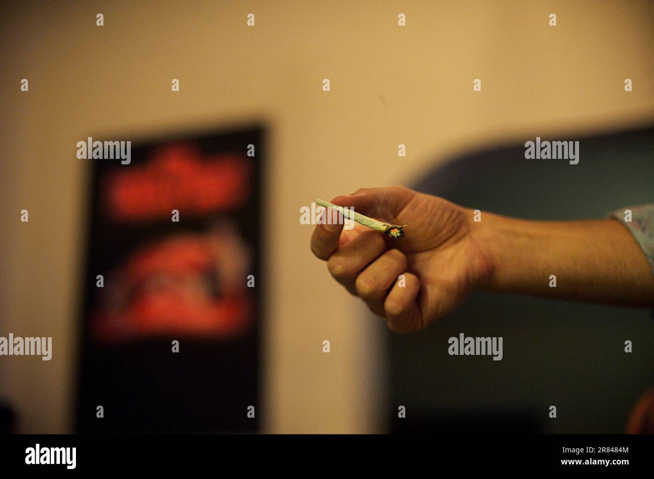 A hand reaches out to pass a marijuana joint in Hollywood, California ...