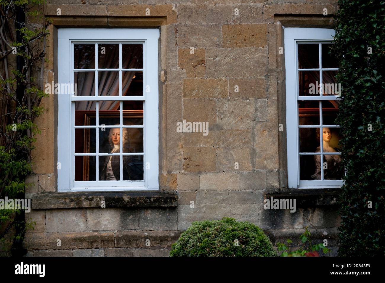 Paintings peer out through the window of a Fine Art Gallery in Broadway ...