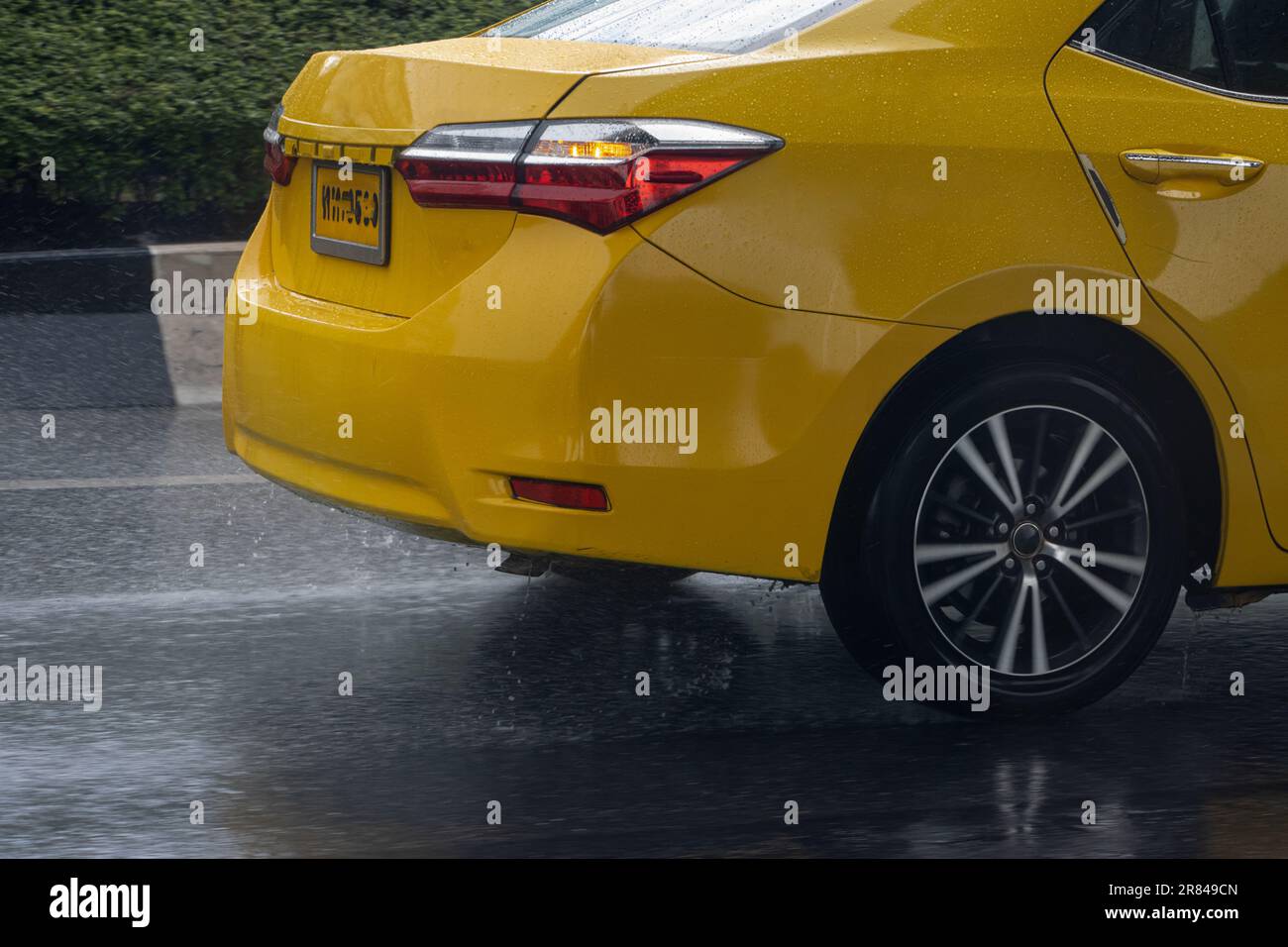 A rear part of a car driving in the rain on a wet road Stock Photo - Alamy