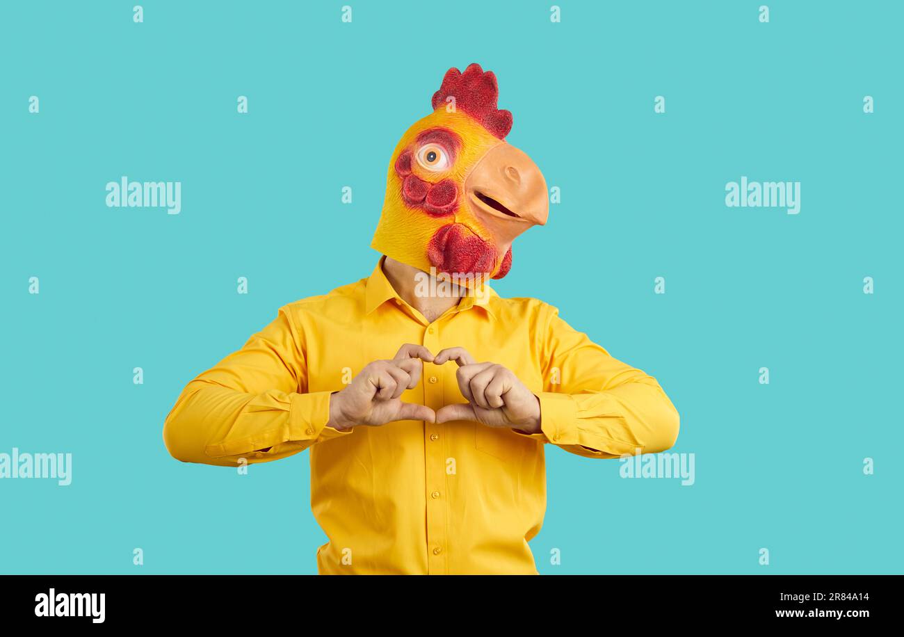 Funny man with comic romantic mood wearing chicken mask on his head ...
