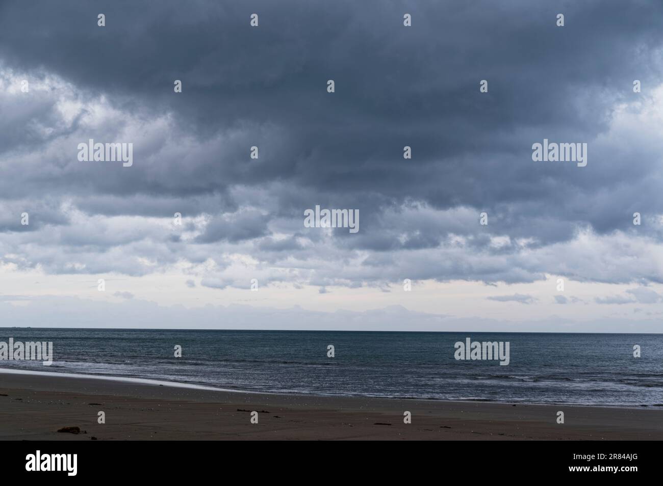 Dark grey clouds gather over the ocean bringing the threat of rain with ...