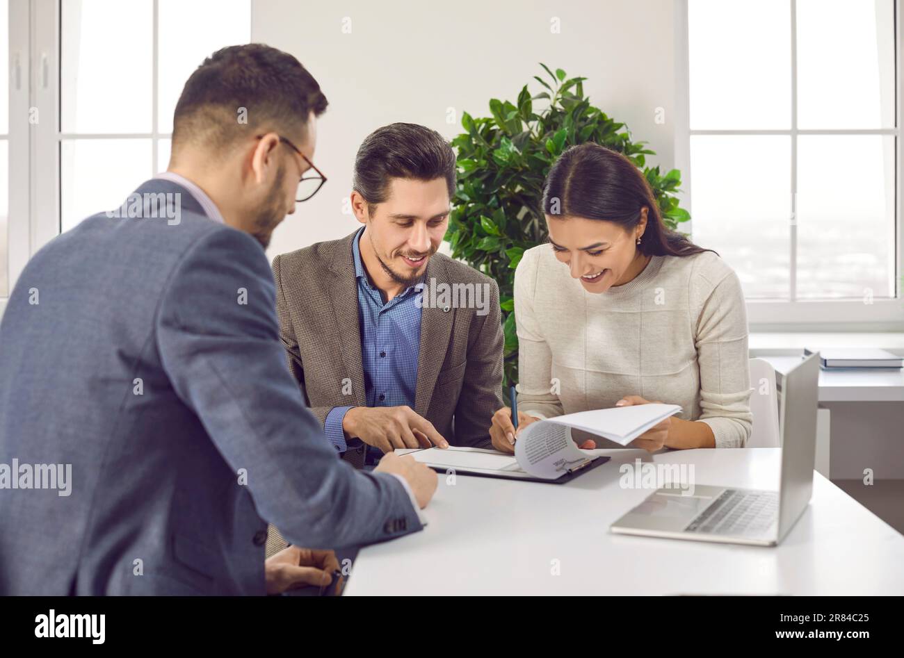 Happy family couple signing paper contract with professional realtor ...