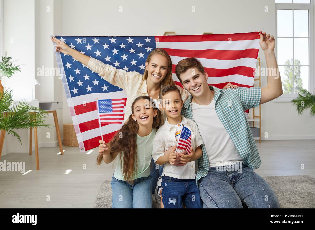 Portrait of a happy, smiling American family with US flags in the ...