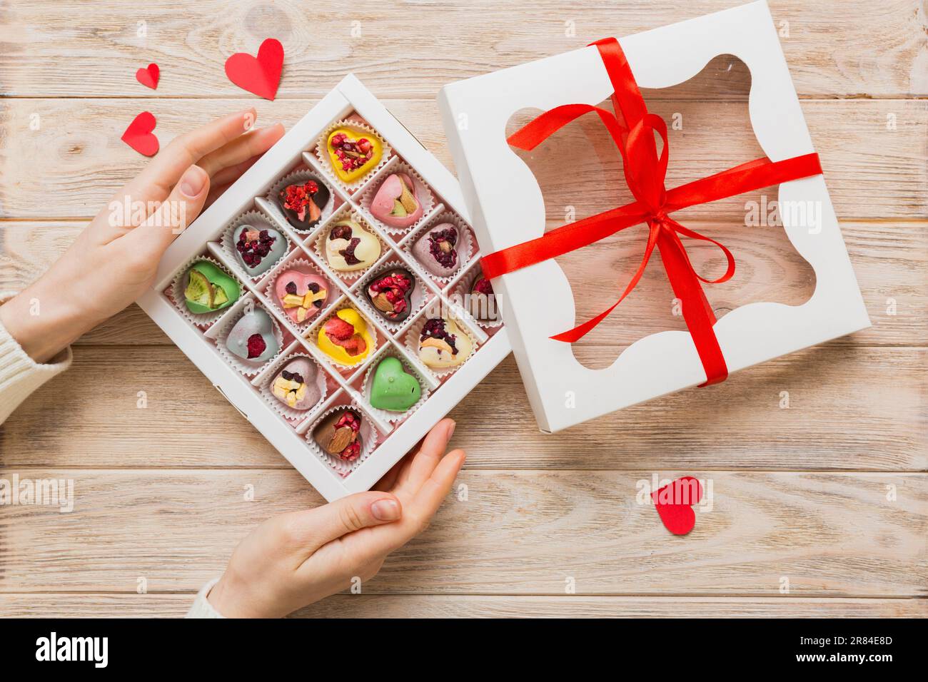 Female hands with delicious candies in box on color background Stock ...