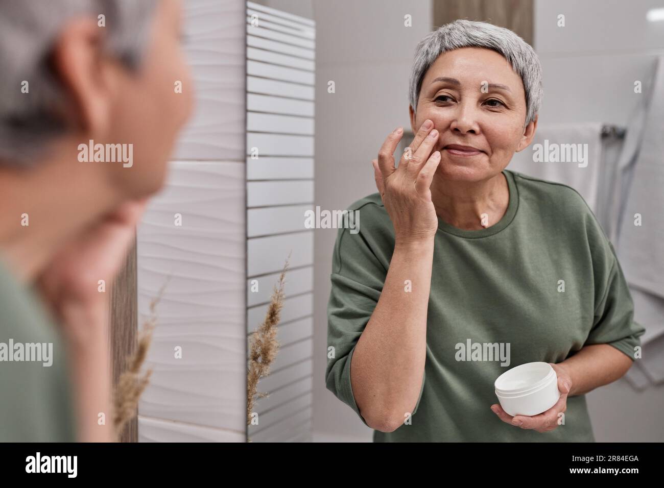 Senior woman with face cream on face hi-res stock photography and ...
