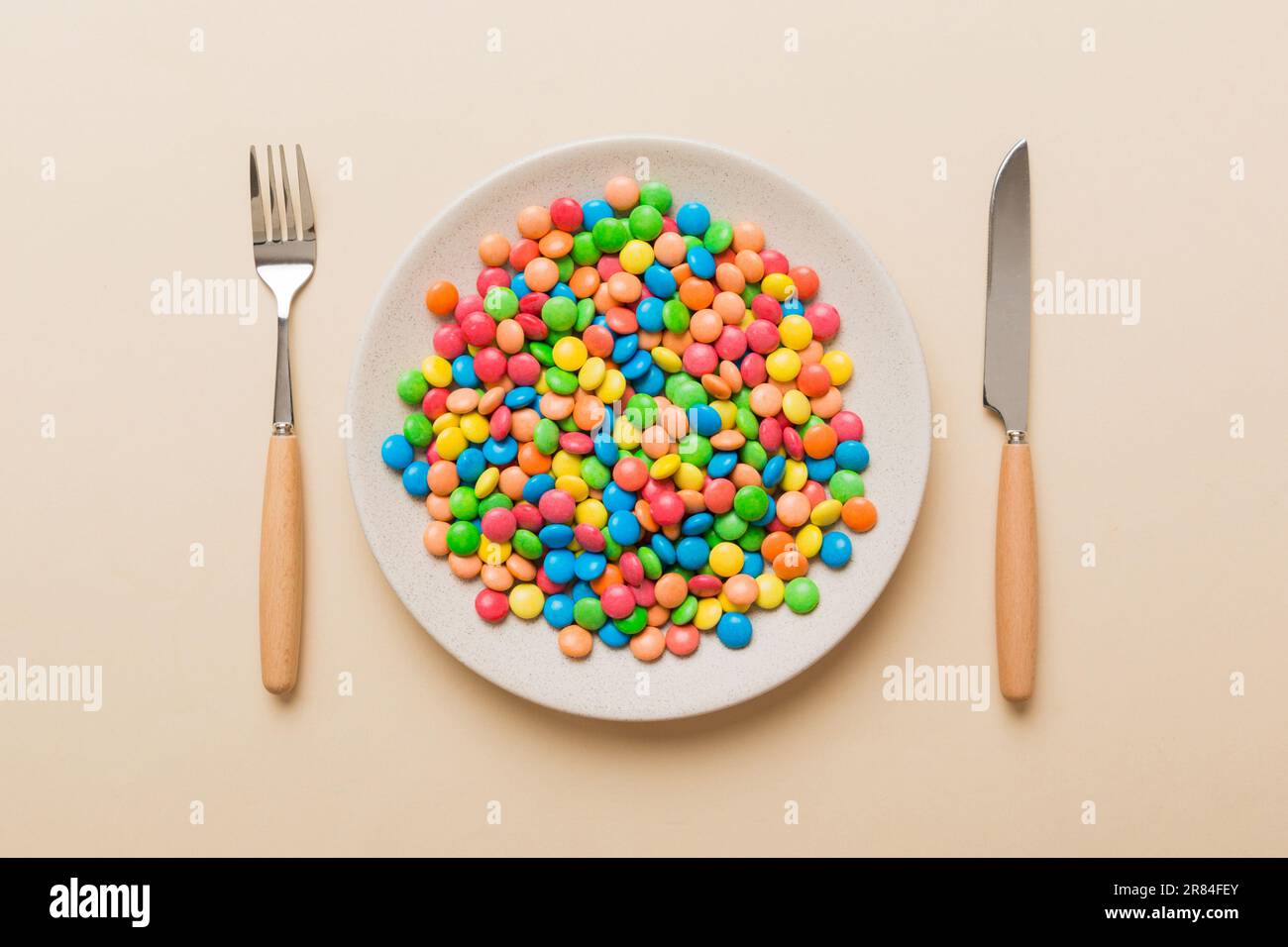 cutlery on table and sweet plate of candy. Health and obesity concept ...