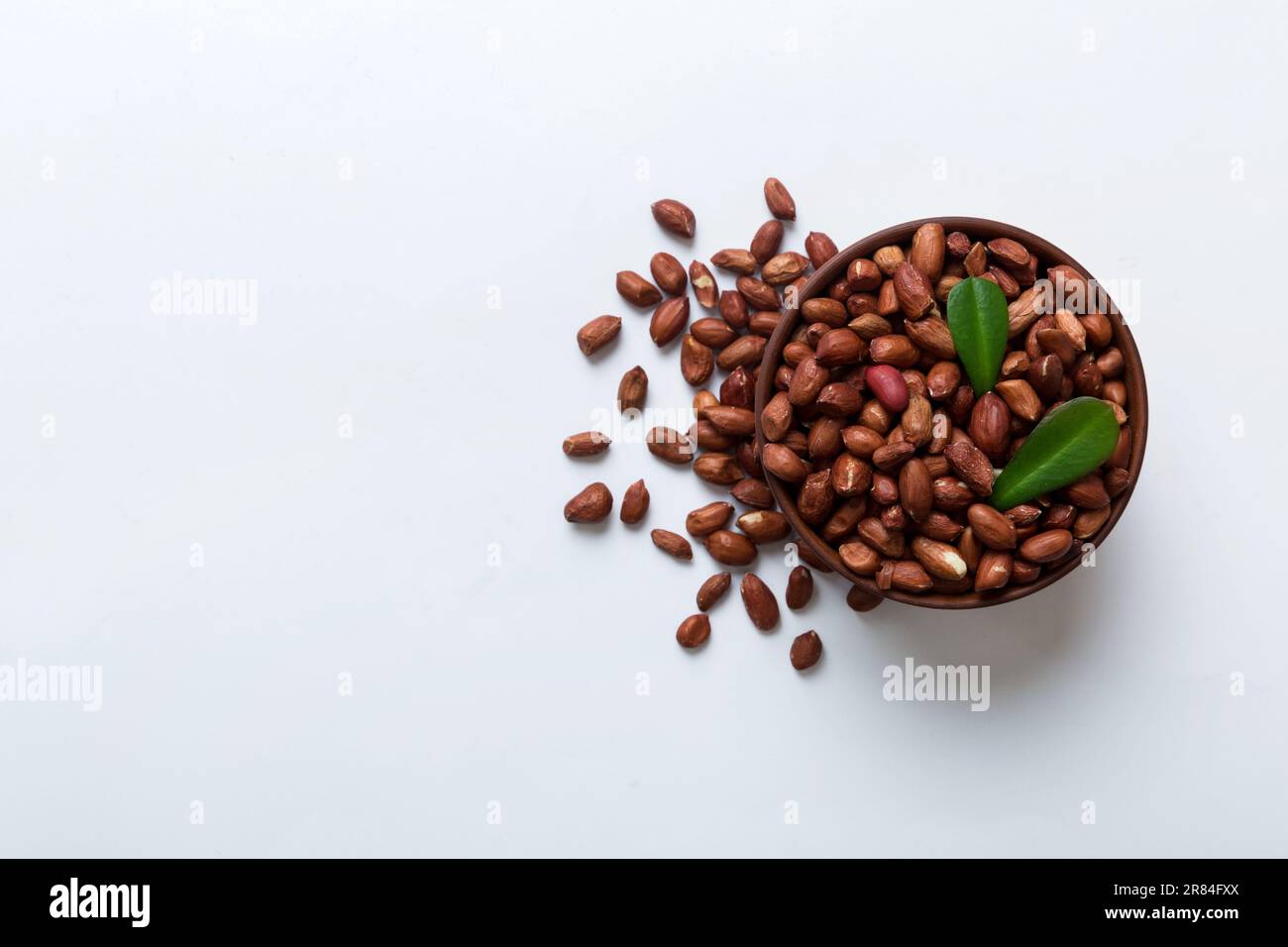 Fresh healthy peanuts in bowl on colored table background. Top view Healthy eating bertholletia ...