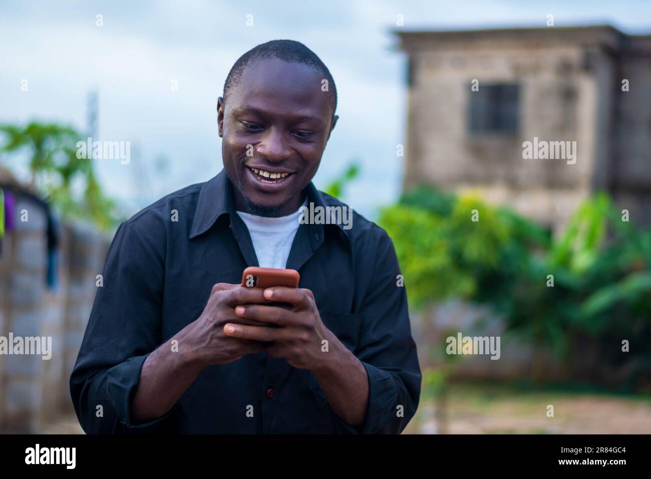 excited black man using his mobile phone. making use of wireless ...