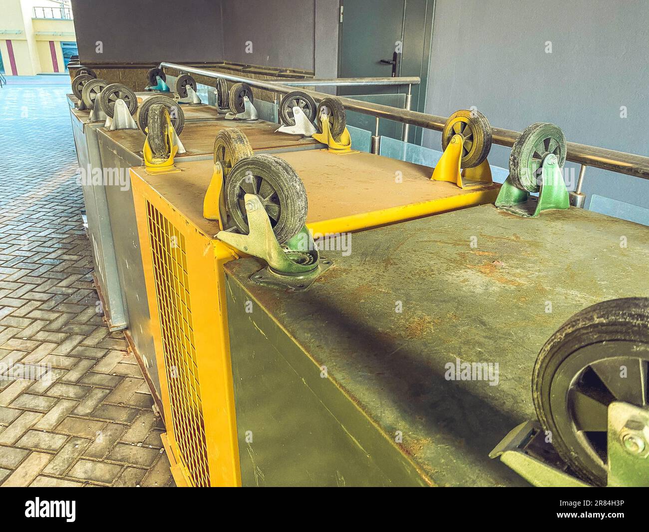 garbage can wheels. garbage containers of different colors lie upside ...
