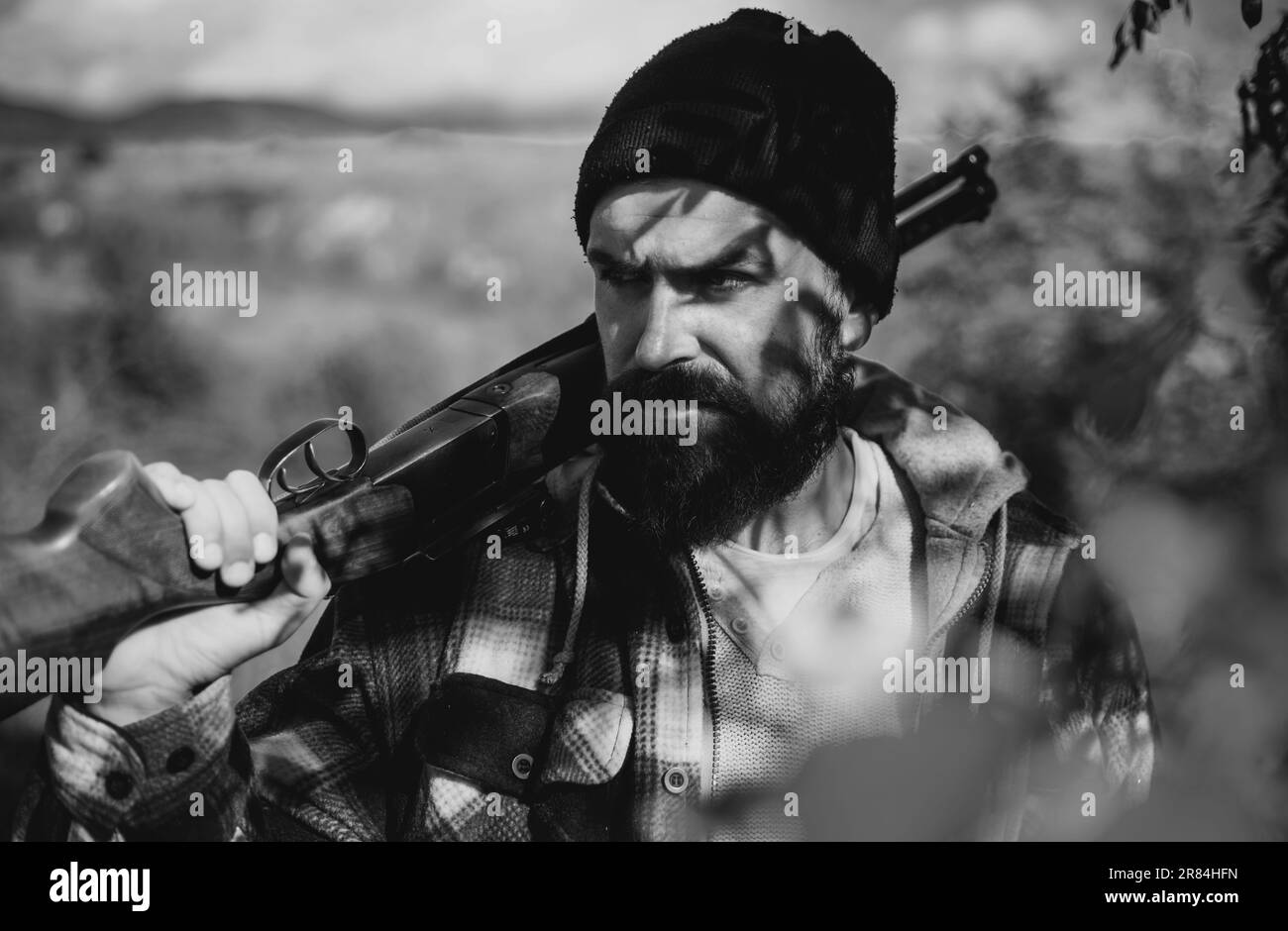 Poacher in the Forest. Bearded hunter man holding gun and walking in ...