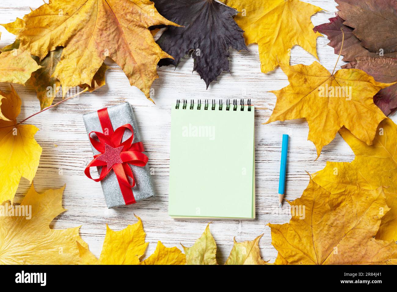 Spiral notepad with pen and gift box on desk Stock Photo - Alamy