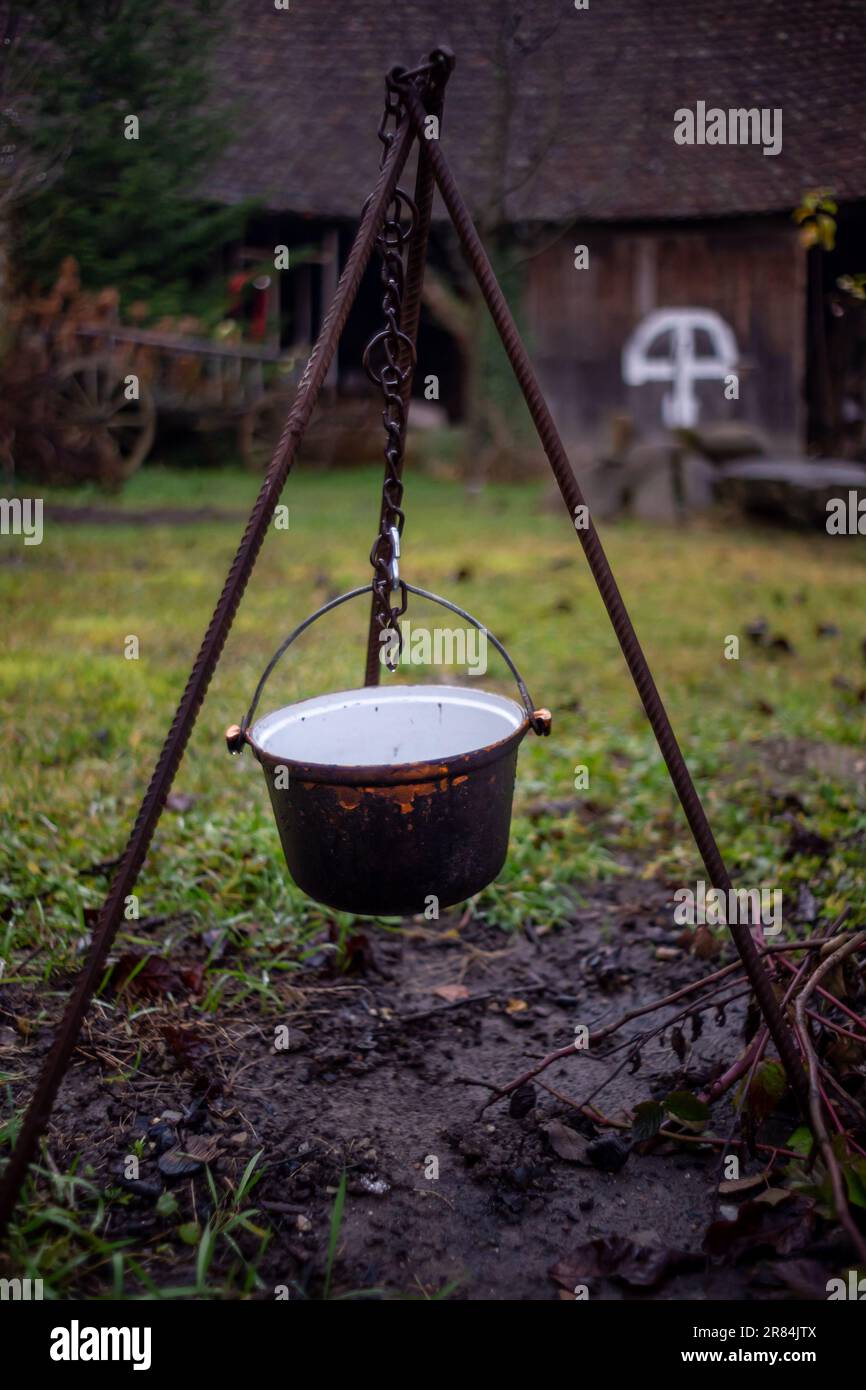 A vertical of a cooking pot hanging over a campfire Stock Photo - Alamy