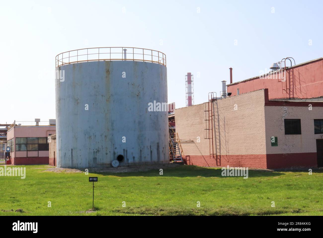 A large gray container with an open hatch and production buildings in ...