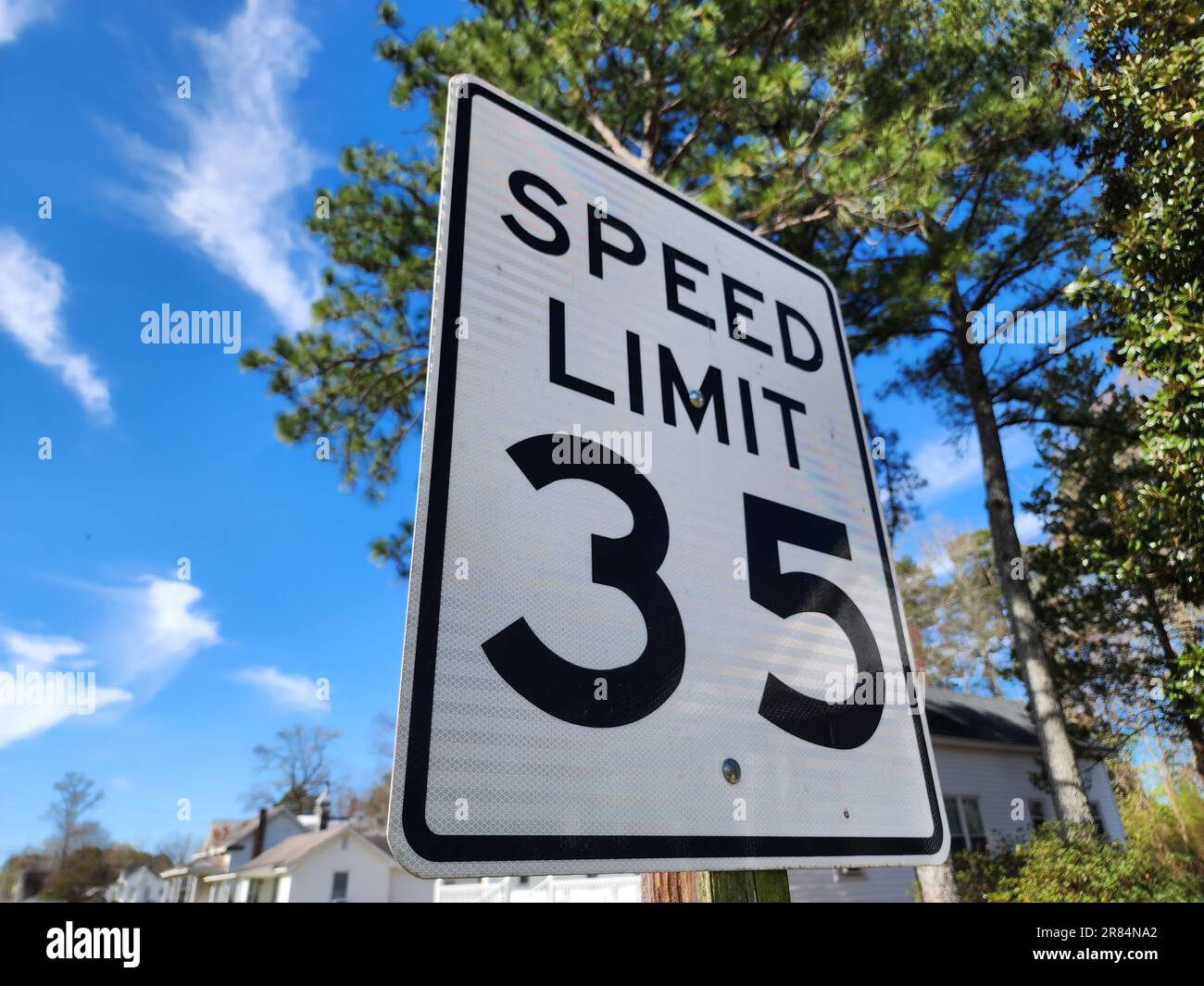 A closeup of 35 speed limit road sign under the blue sky with a blurry ...