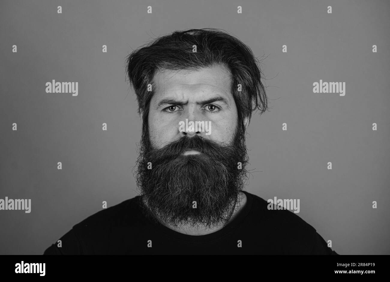 Portrait Of Confident Serious Man Has Beard And Mustache Looks