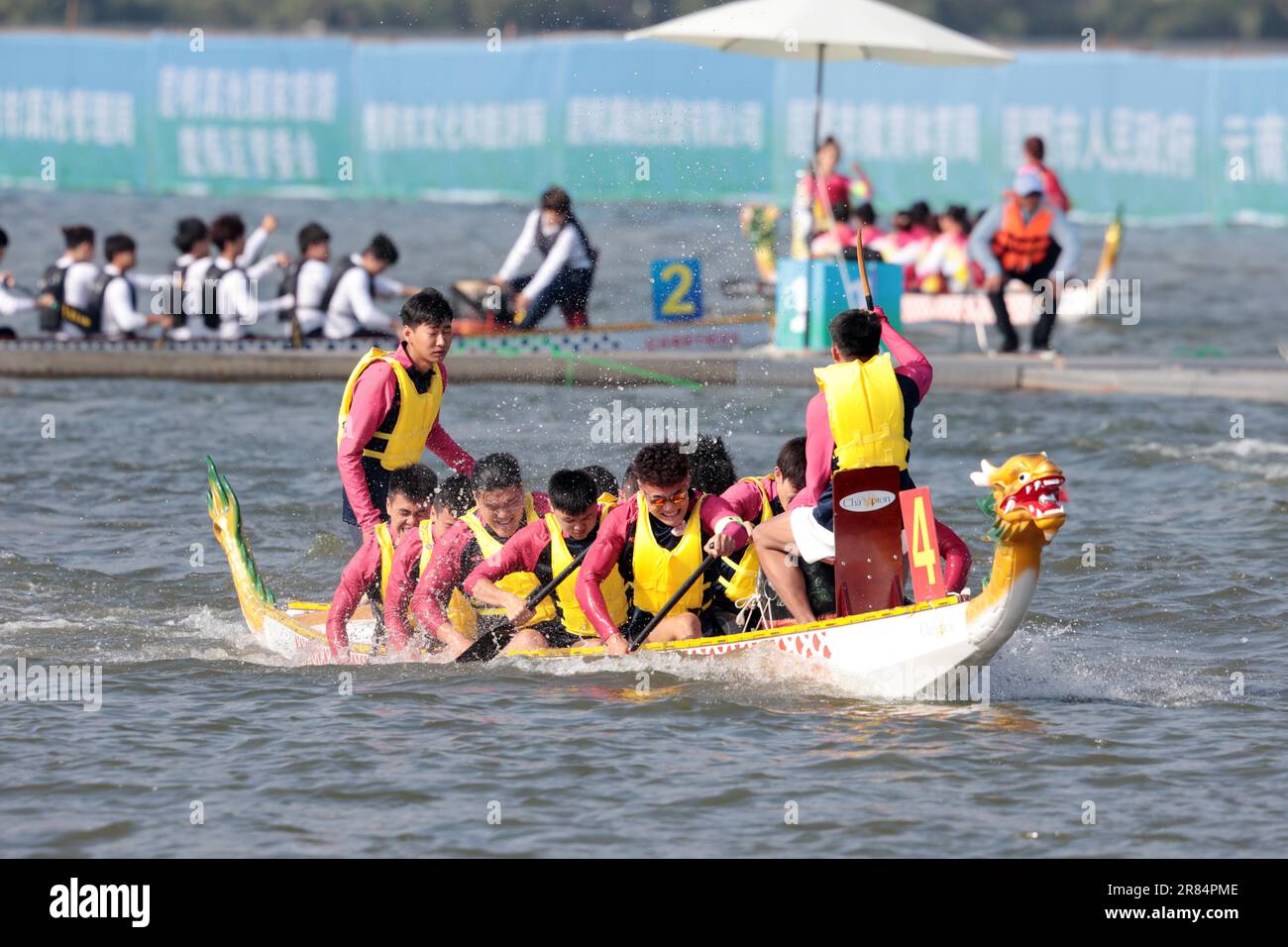 People compete at a dragon boat racing event in Kunming City, southwest ...