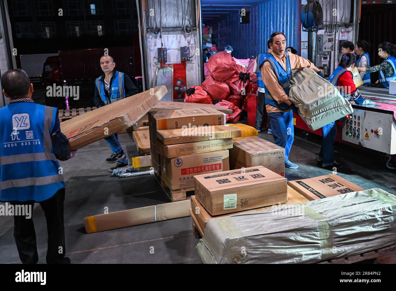 Workers sort parcels at a sorting center of JD Express in Chongqing ...